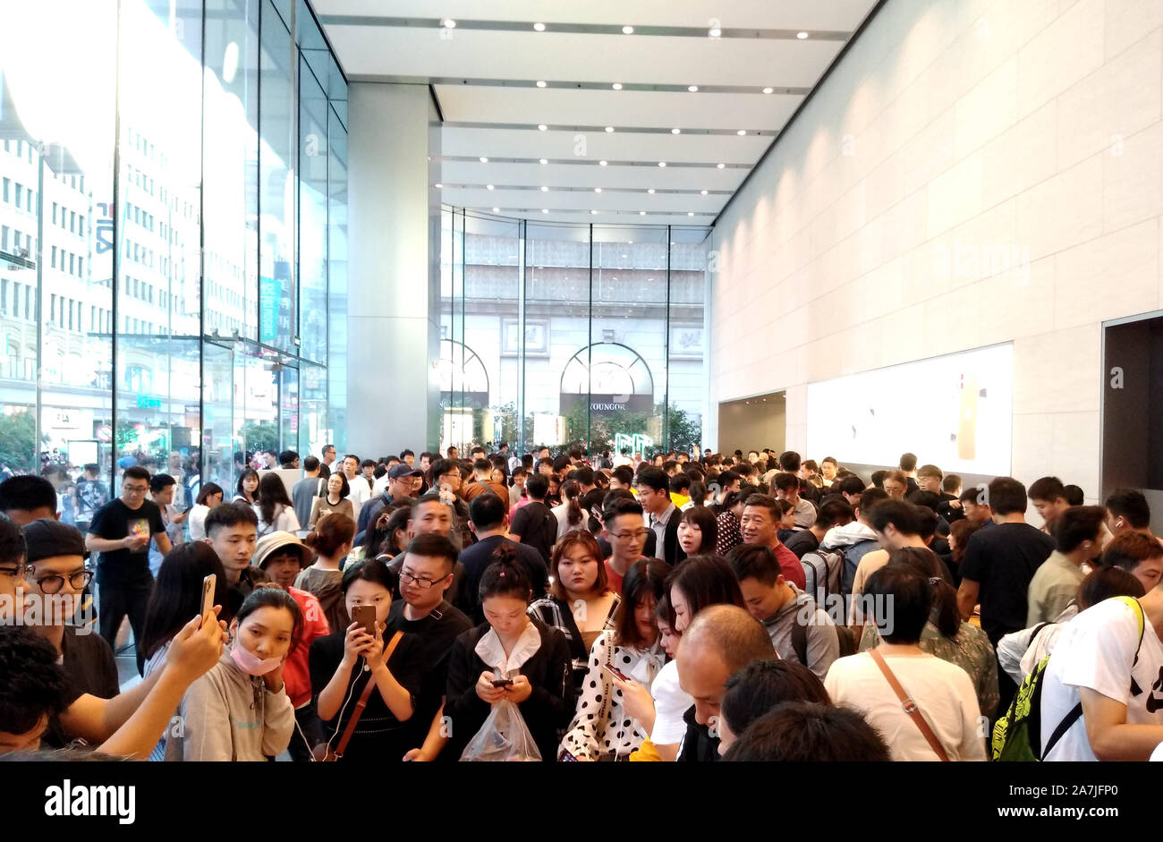 The Apple retail store is crowded with fans waiting to experience the ...