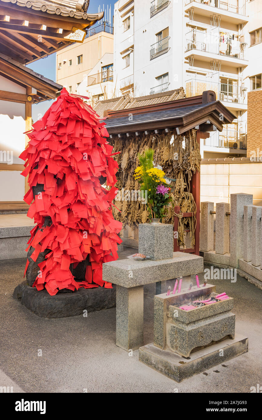 Statue of the Buddhist deity Akagami Nio covered with red papers ...