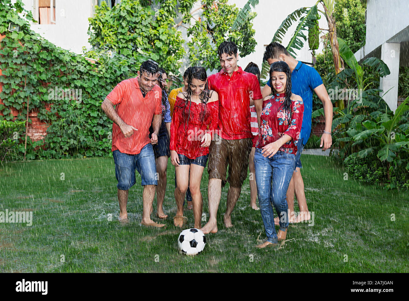 Happy Adult Friends male And Female Friends Playing Soccer ball Game In ...