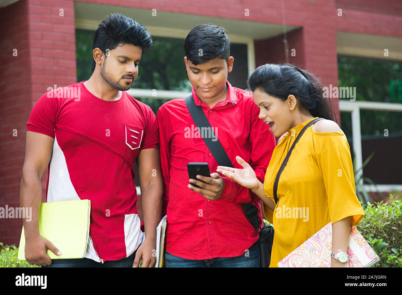 Surprised Three College students Friends Looking-At Cell-Phone Screen ...