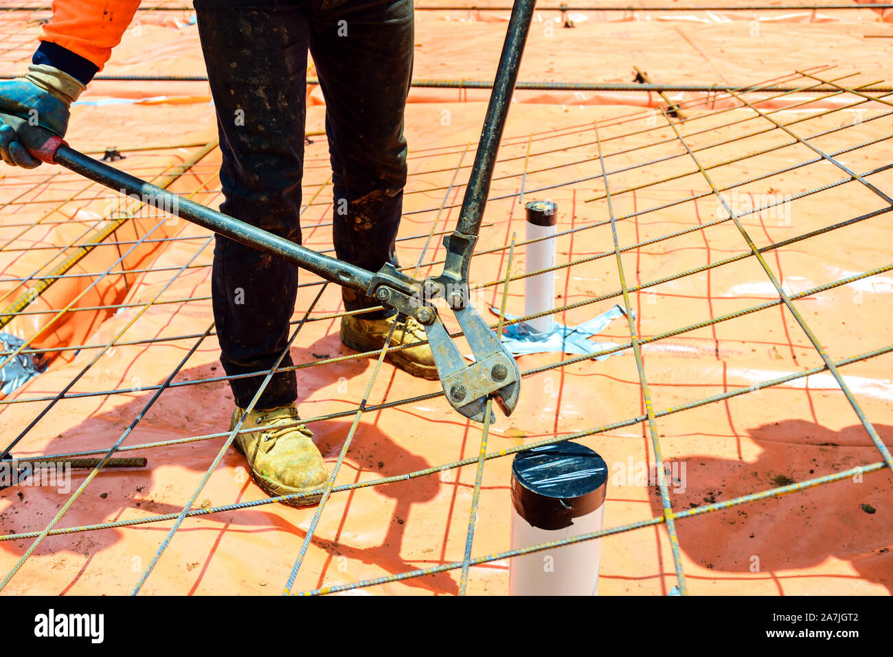 Australian builder performing steel fixing works by cutting mesh for ...