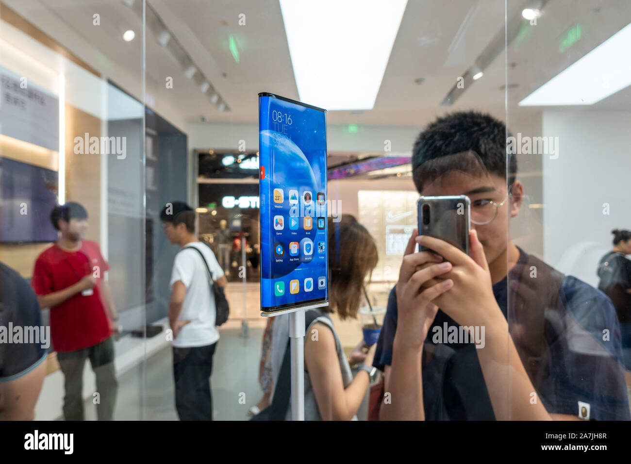 People take pictures of a MIX Alpha phone displayed in a Millet House ...