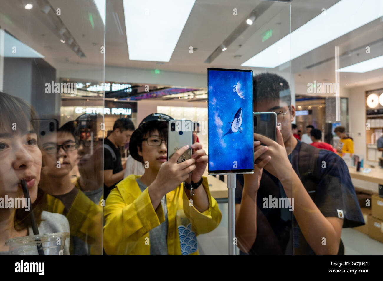 People take pictures of a MIX Alpha phone displayed in a Millet House ...
