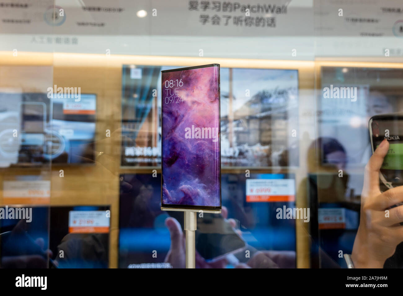 People take pictures of a MIX Alpha phone displayed in a Millet House ...