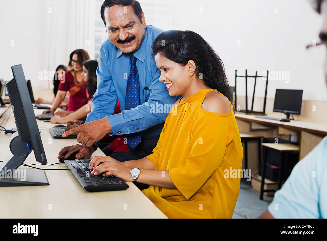 Indian College Professor Helping Girl Student with computer lesson ...