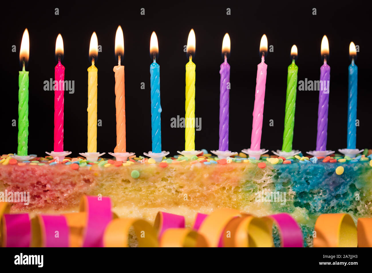 many coloured cake with candles in front of black background Stock ...
