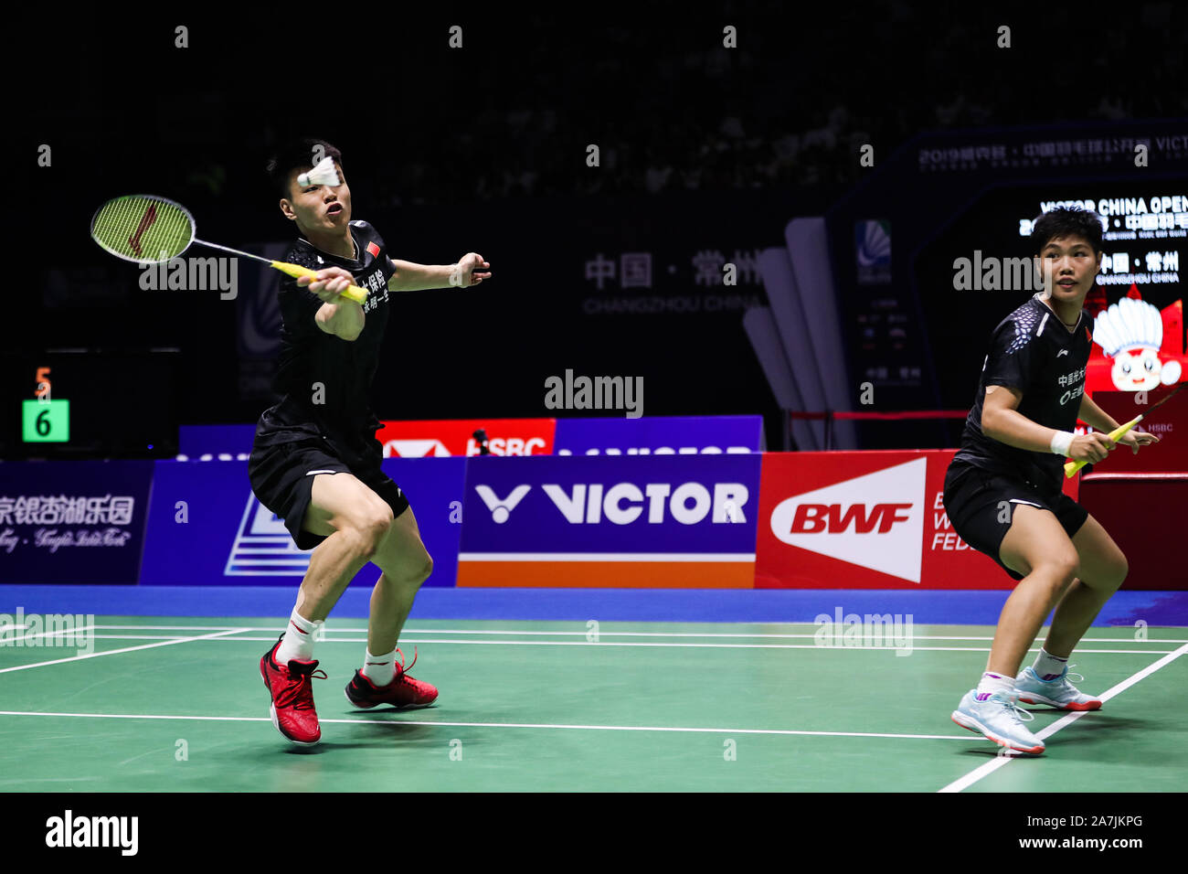 Chinese professional badminton players Wang Yilv and Huang Dongping compete against Chinese ...