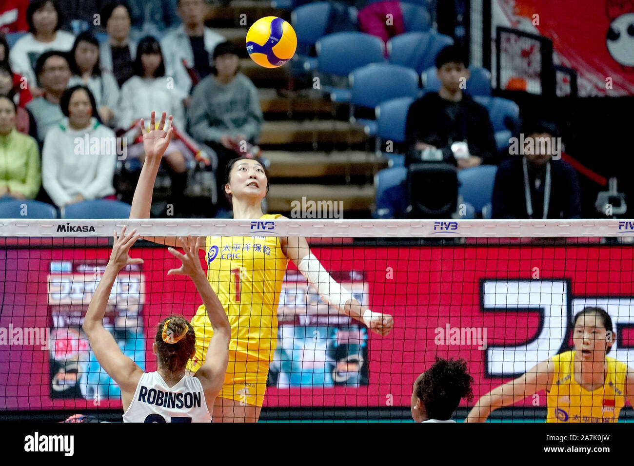 Yuan Xinyue of China, middle, spikes the ball during the second-round ...