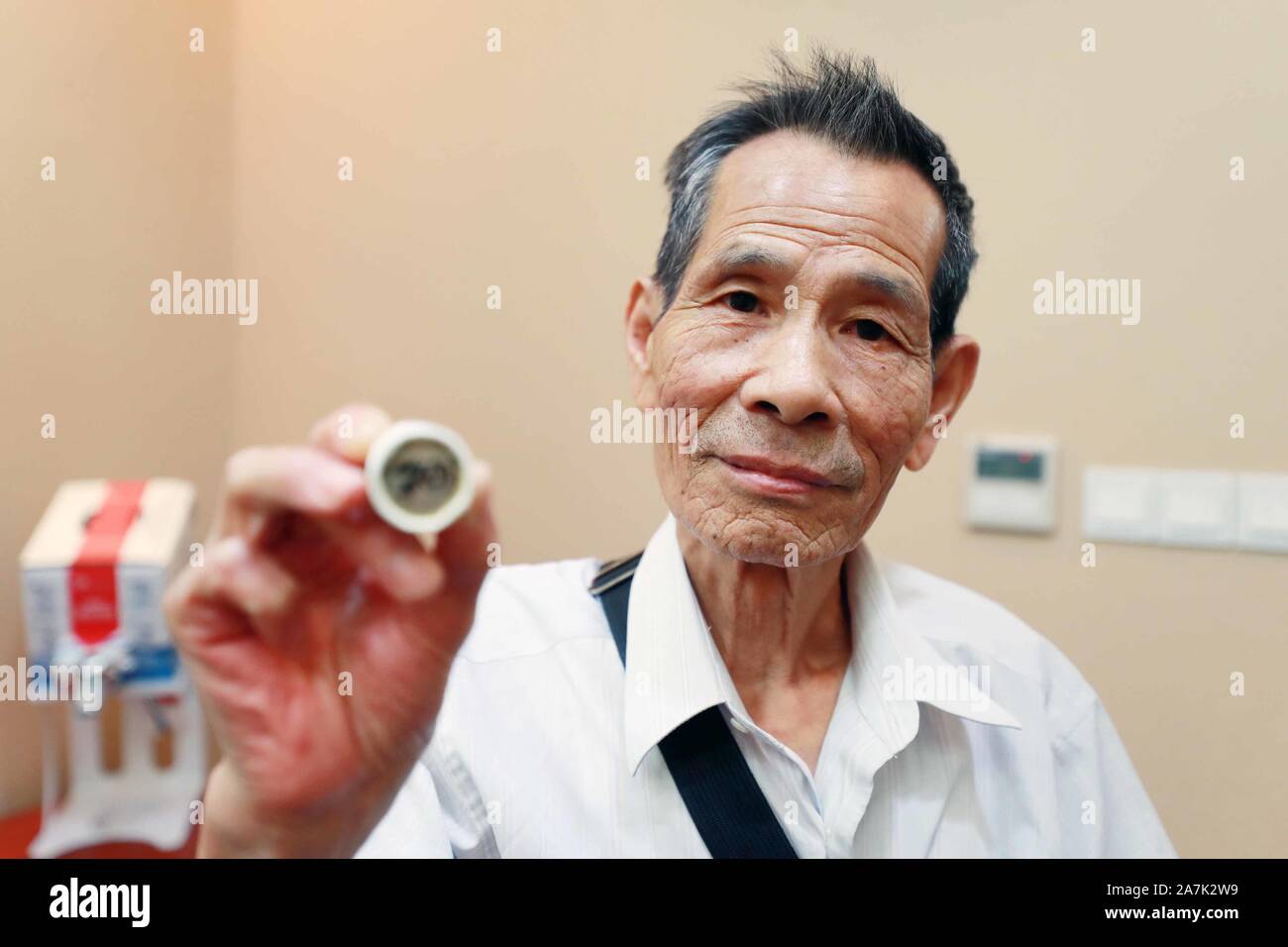 A commemorative coin lover demonstrates his gain of the 10 Yuan ...