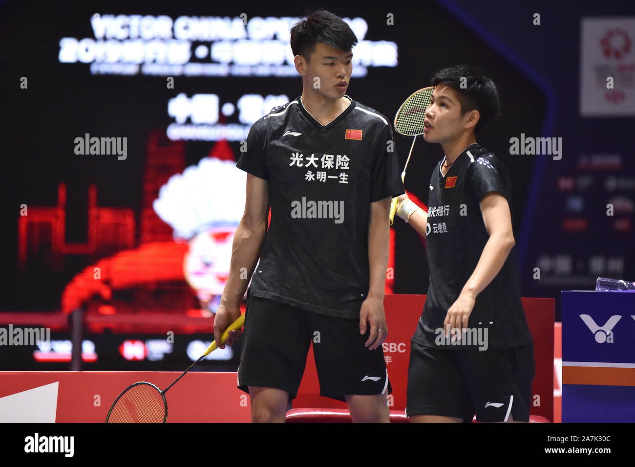 Chinese professional badminton players Wang Yilv and Huang Dongping compete against Chinese ...