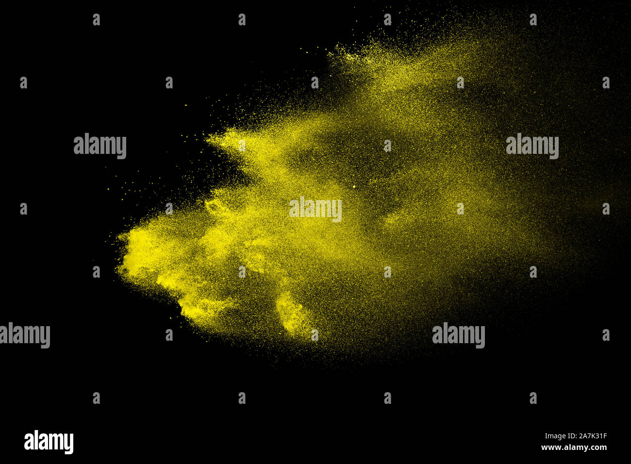 Abstract yellow powder splatter on black background. Freeze motion of ...