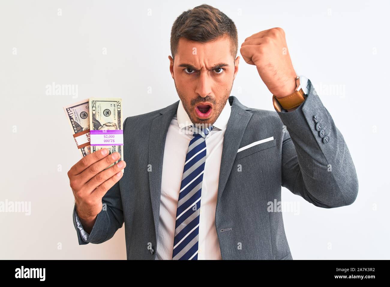 Young handsome business man holding bunch of dollars banknotes over ...