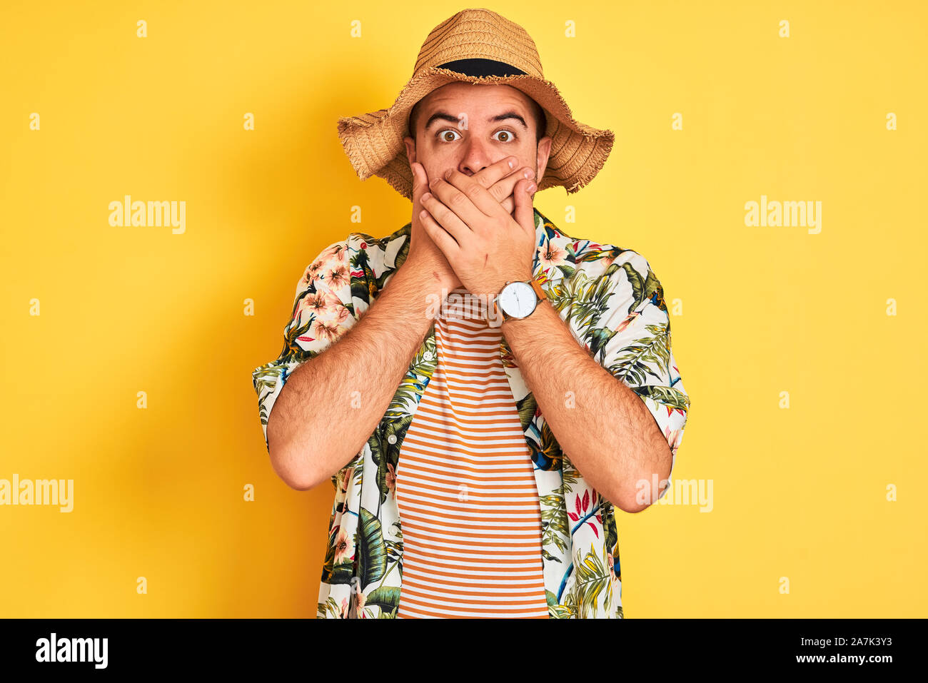 Young man on vacation wearing summer shirt and hat over isolated yellow ...