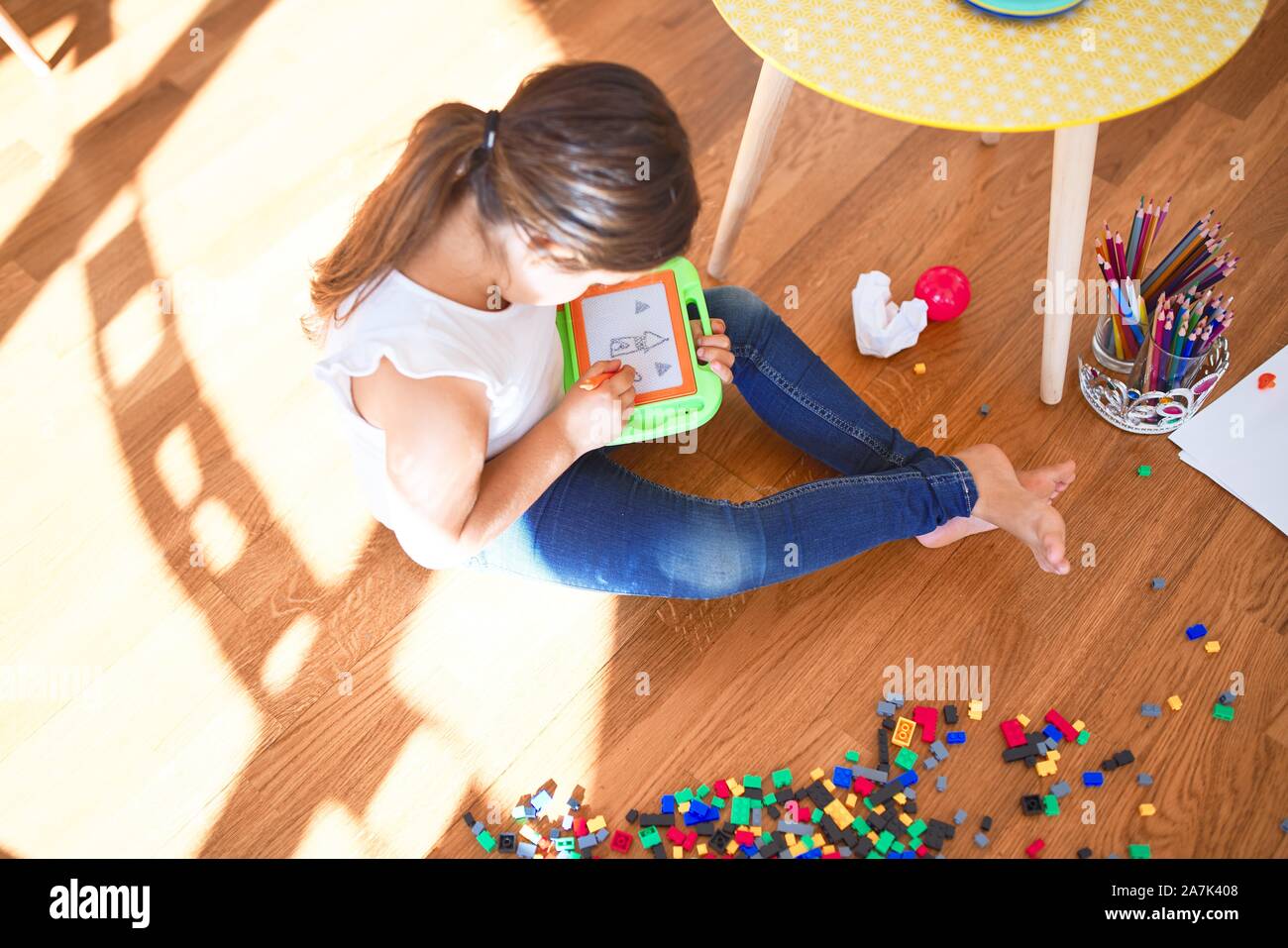Adorable toddler drawing using digital board around lots of toys at ...
