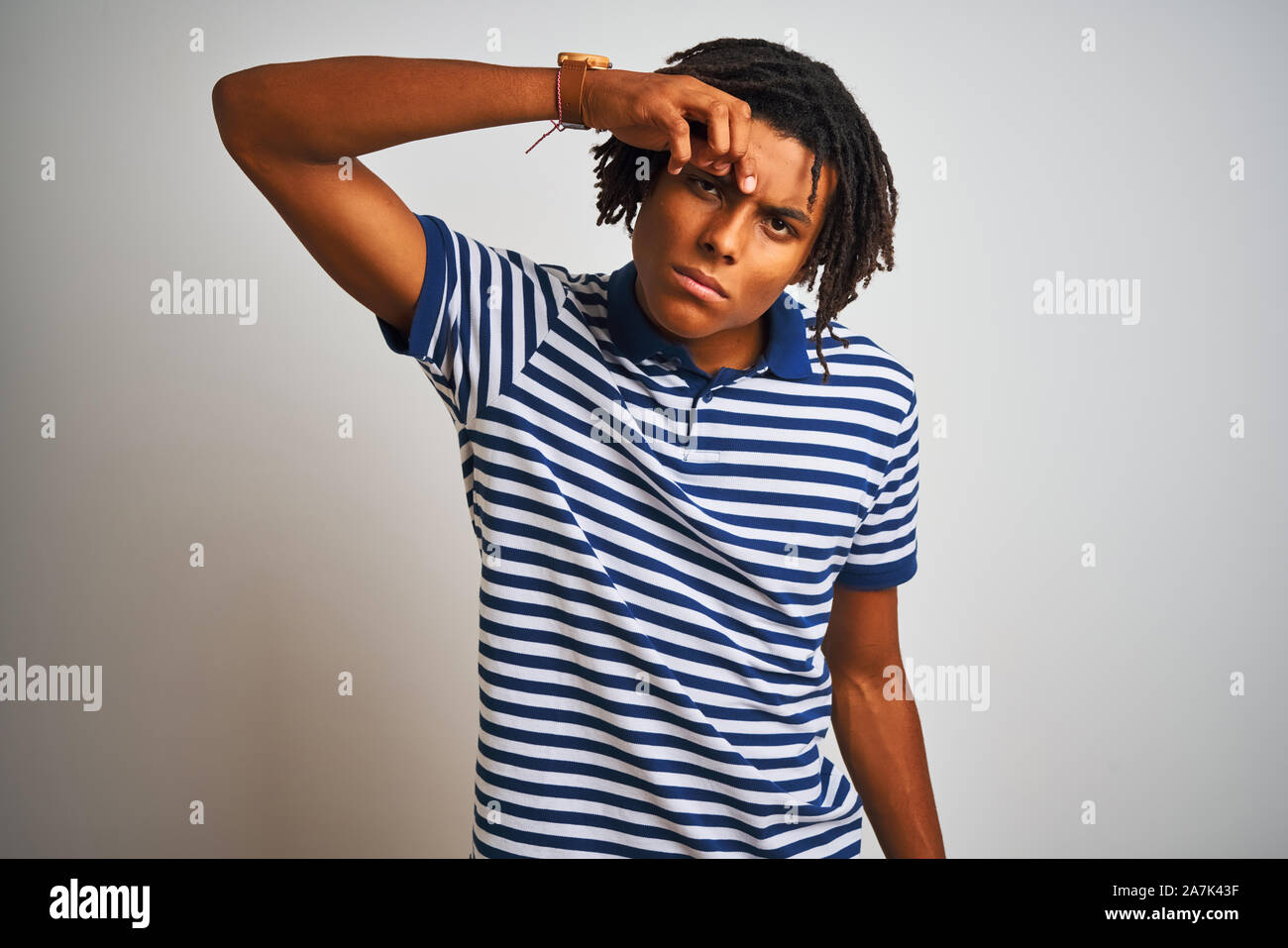 Afro man with dreadlocks wearing striped blue polo standing over ...