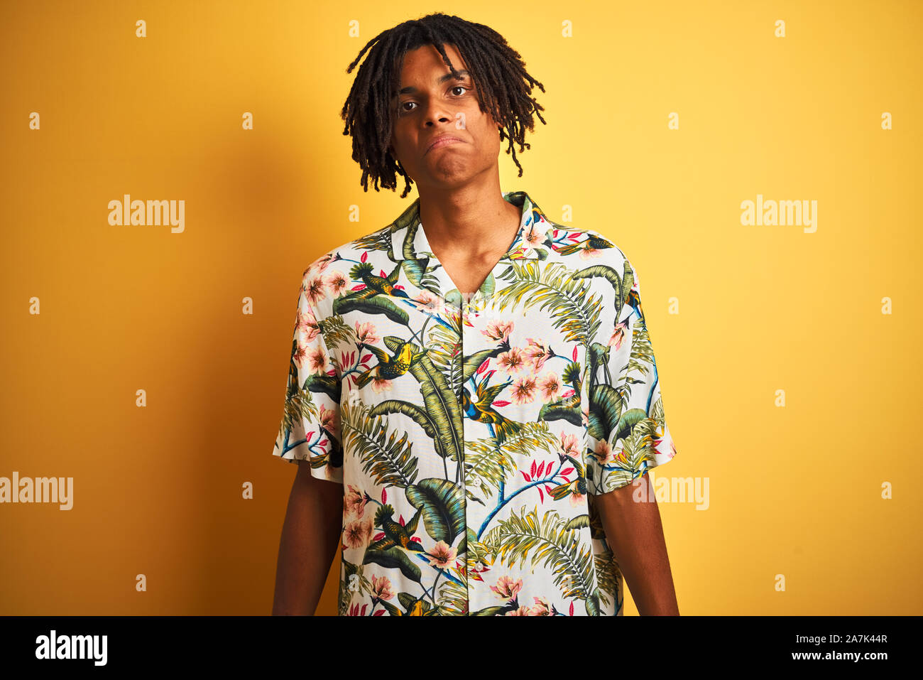 Afro man with dreadlocks on vacation wearing summer shirt over isolated ...