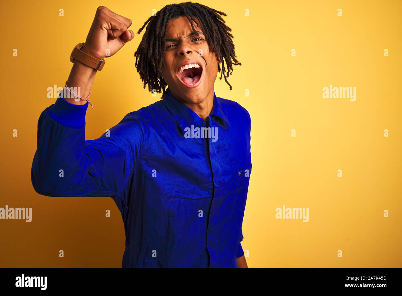 Afro worker man with dreadlocks wearing mechanic uniform over isolated ...