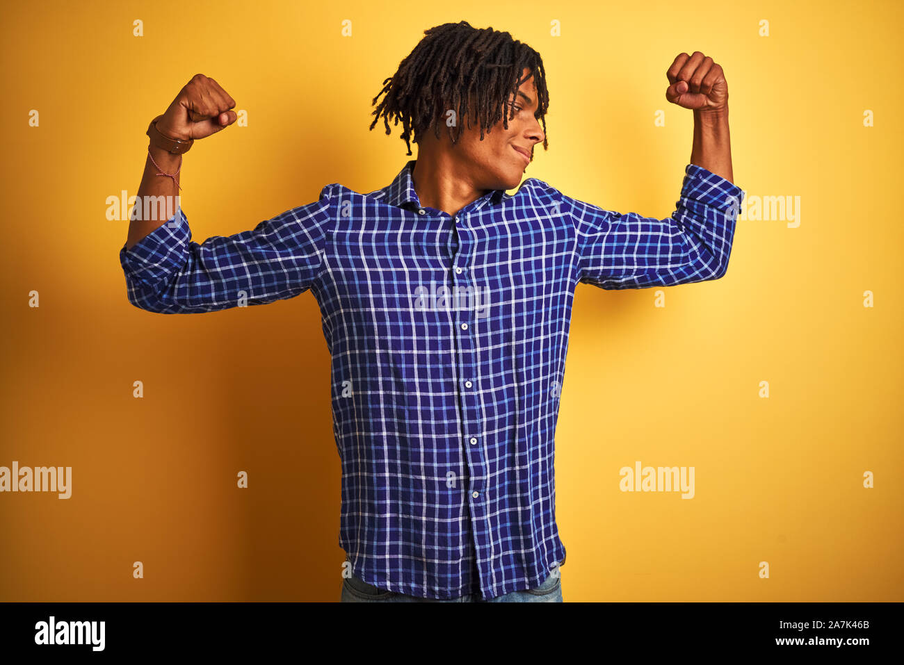 Afro man with dreadlocks wearing casual shirt standing over isolated ...