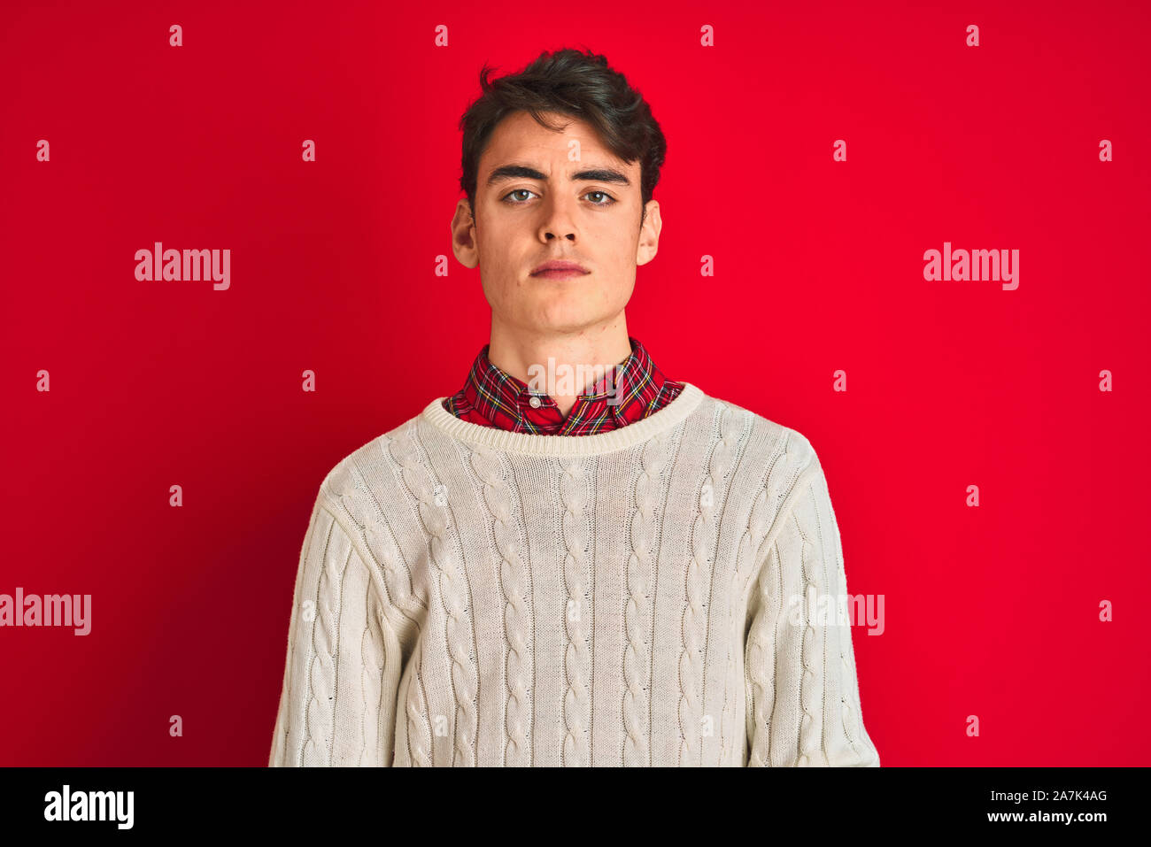 Teenager boy wearing a sweater standing over pink isolated background ...