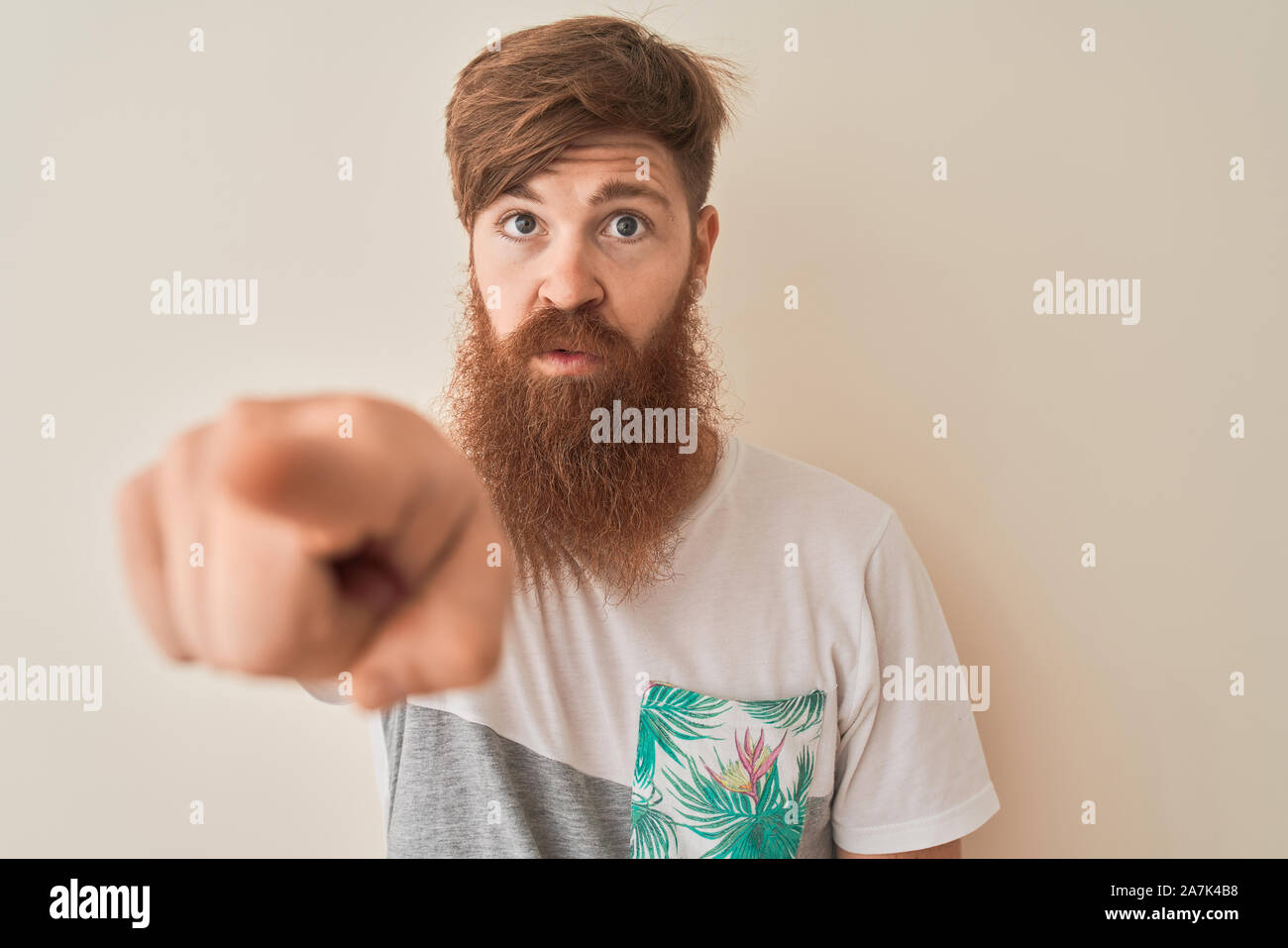 Young redhead irish man wearing t-shirt standing over isolated white ...