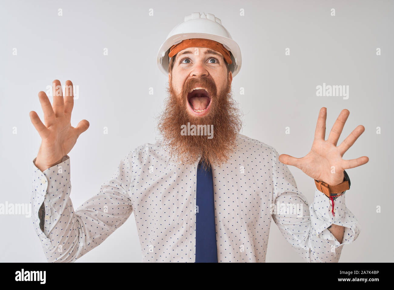 Young redhead irish architect man wearing security helmet over isolated ...
