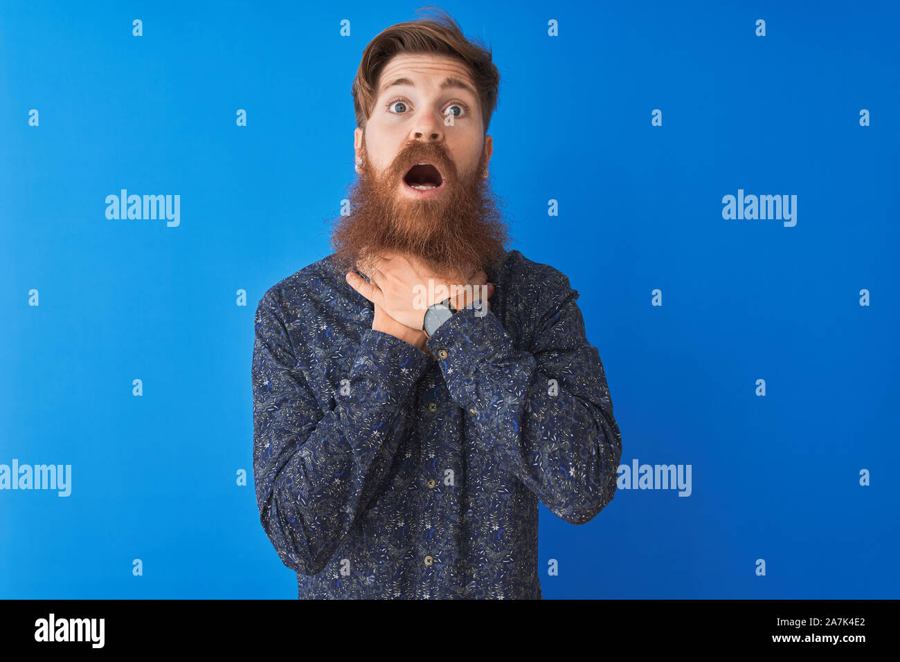 Young redhead irish man wearing floral summer shirt standing over ...