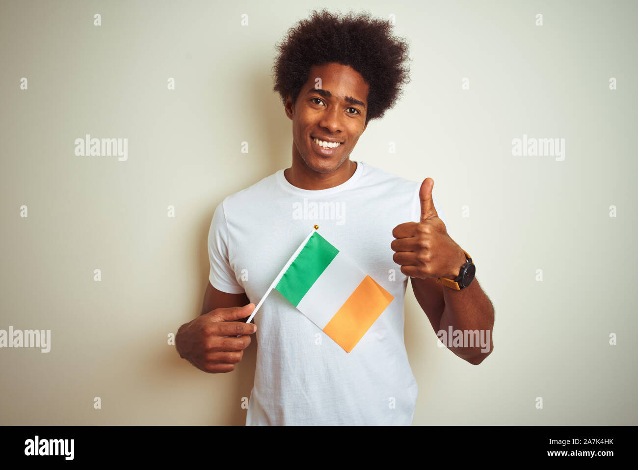 Young african american man holding Ireland Irish flag standing over ...