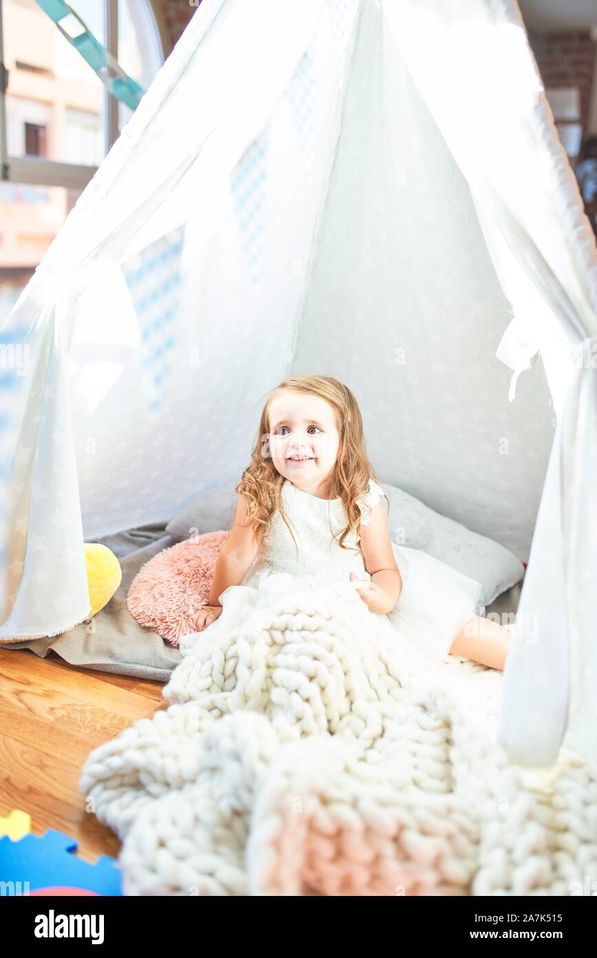 Adorable blonde toddler playing sitting on blanket inside tipi at ...