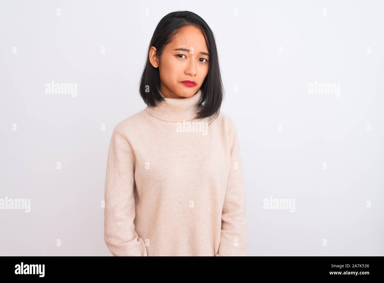 Young chinese woman wearing turtleneck sweater standing over isolated ...