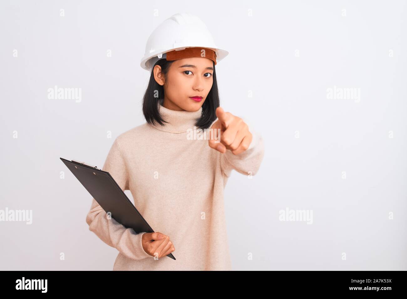 Chinese architect woman wearing helmet holding clipboard over isolated ...