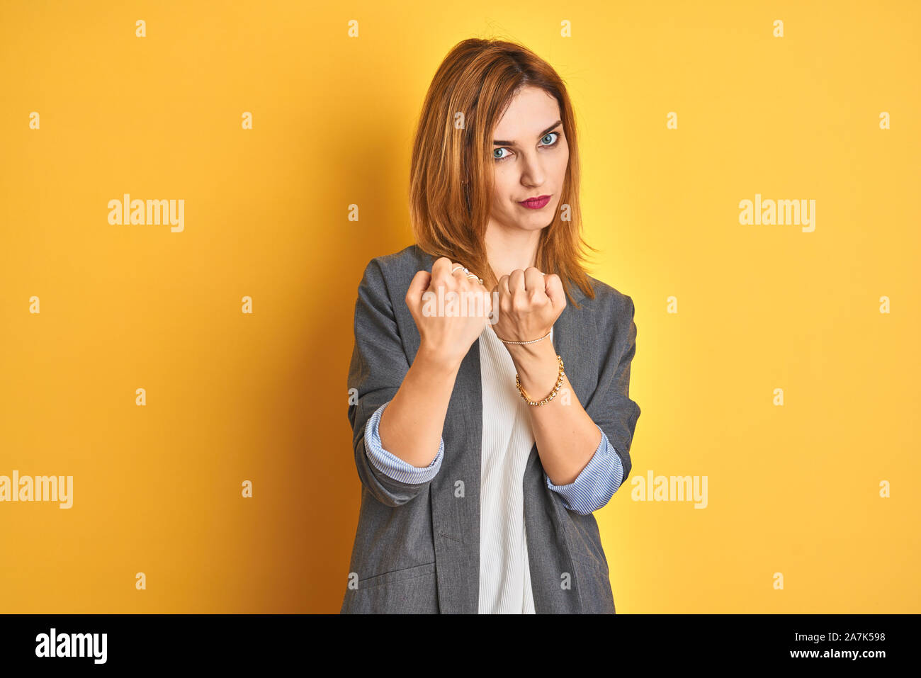 Redhead caucasian business woman over yellow isolated background ...