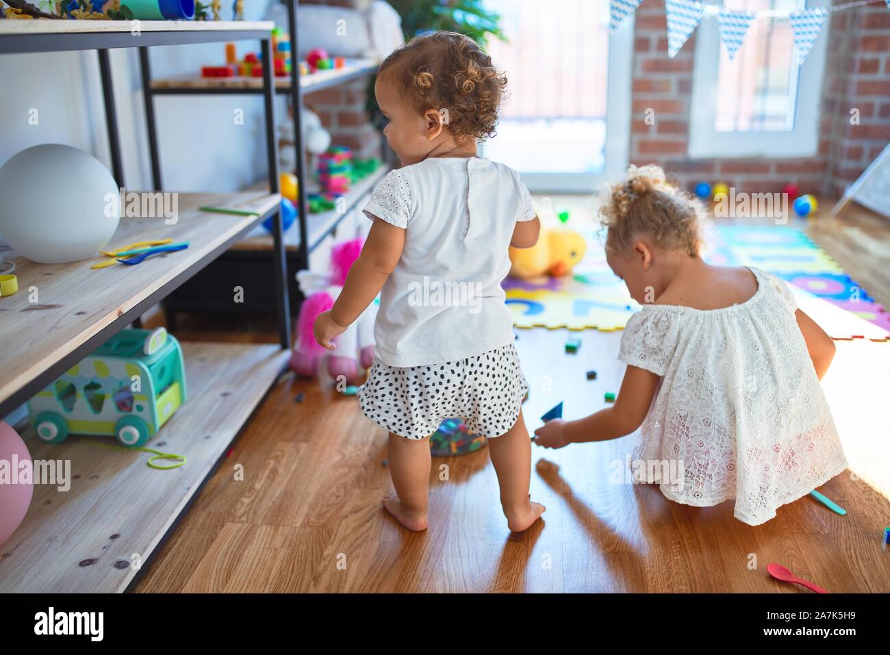 Beautiful toddlers playing around lots of toys at kindergarten Stock ...