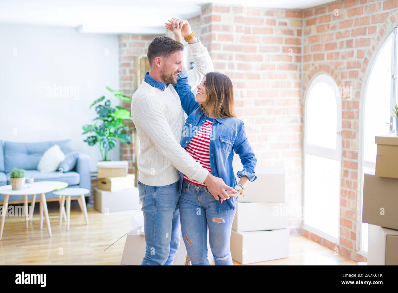Young beautiful couple dancing at new home around cardboard boxes Stock ...