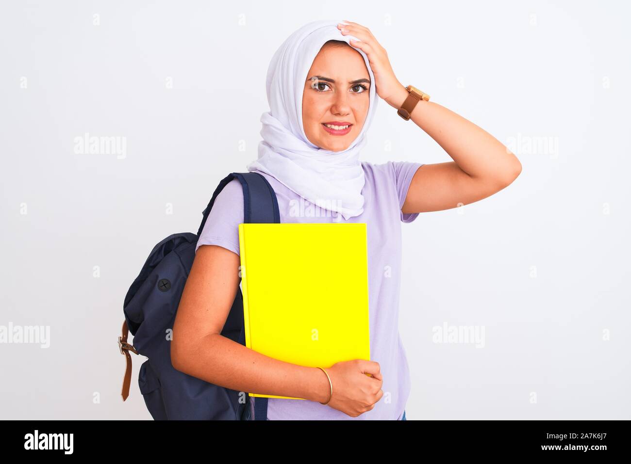 Arab student girl wearing hijab and backpack holding book over isolated ...