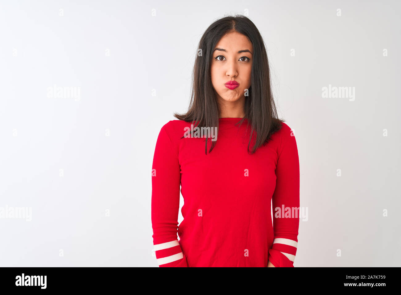 Young beautiful chinese woman wearing red dress standing over isolated ...