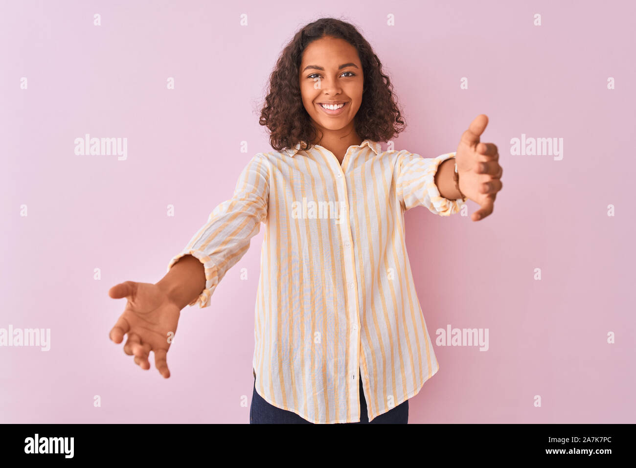 Young Brazilian Woman Wearing Striped Shirt Standing Over Isolated Pink