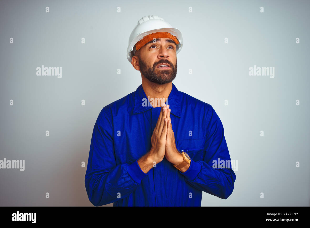 Handsome indian worker man wearing uniform and helmet over isolated ...