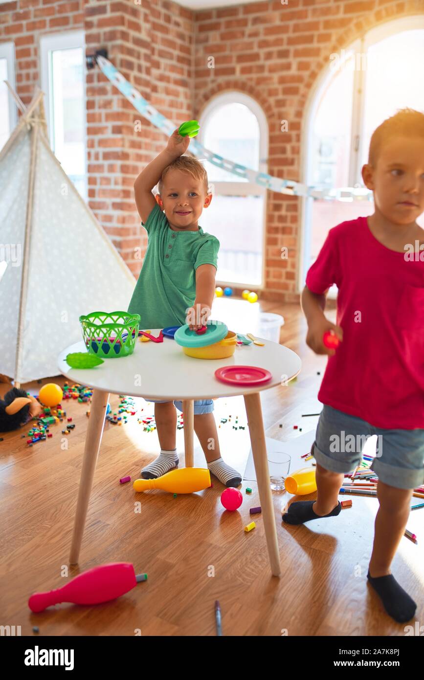 Adorable toddlers playing around lots of toys at kindergarten Stock ...