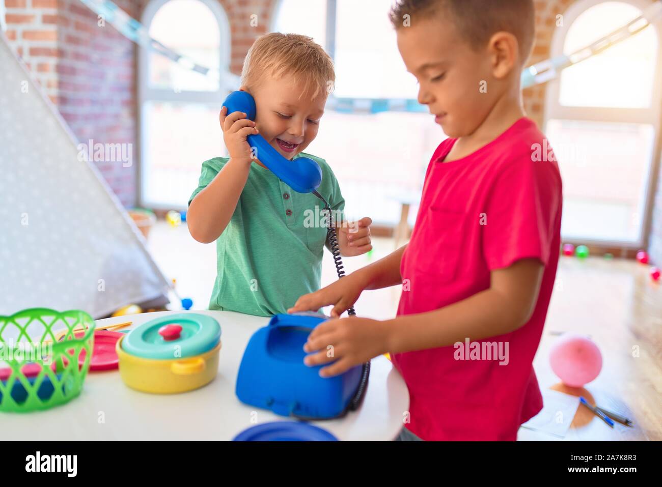 Adorable toddlers playing around lots of toys at kindergarten Stock ...