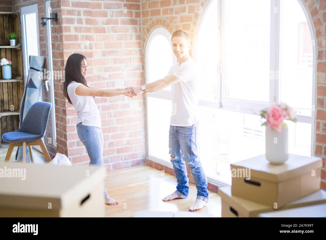 Young beautiful couple dancing at new home around cardboard boxes Stock ...