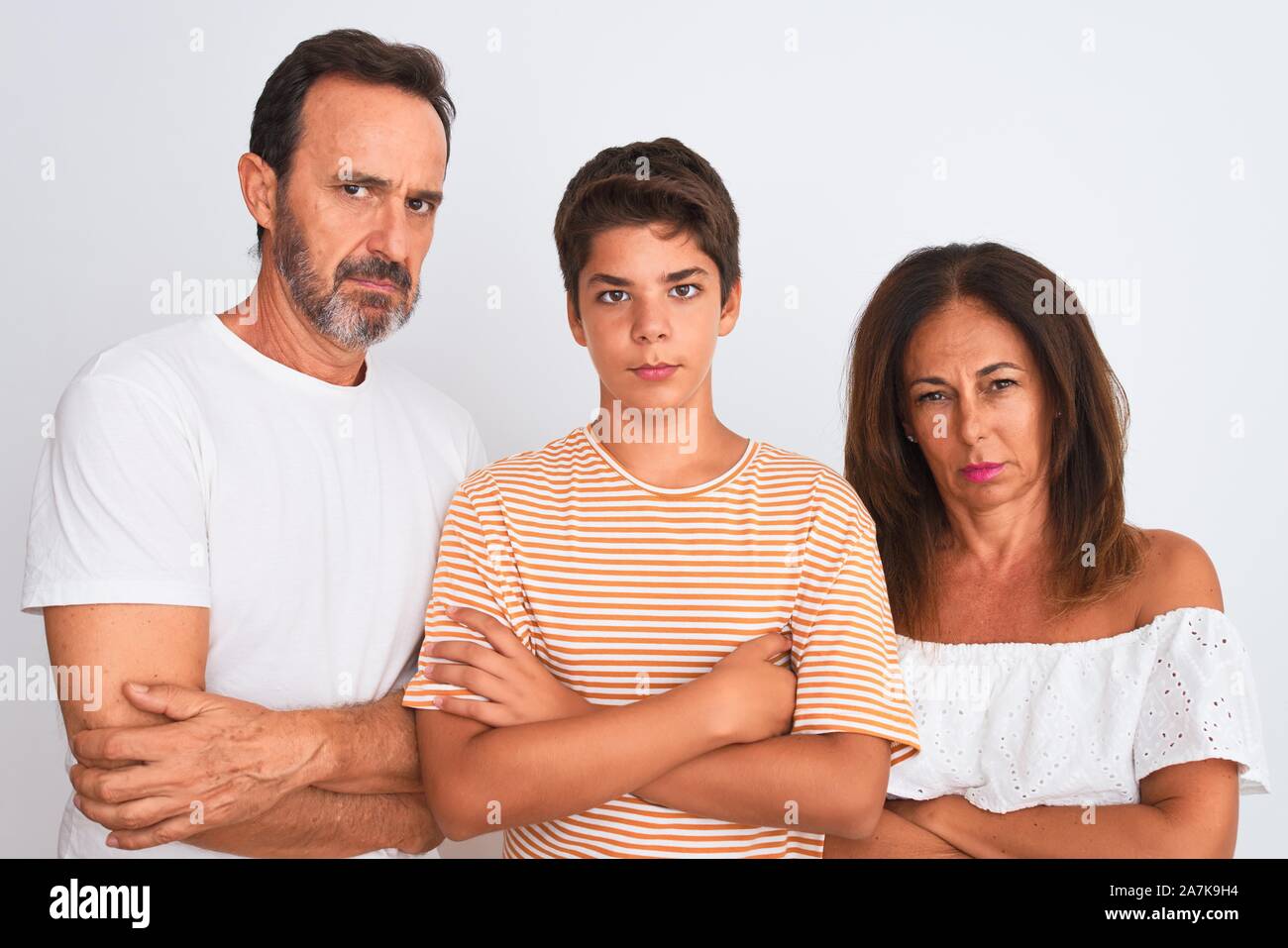 Family of three, mother, father and son standing over white isolated ...
