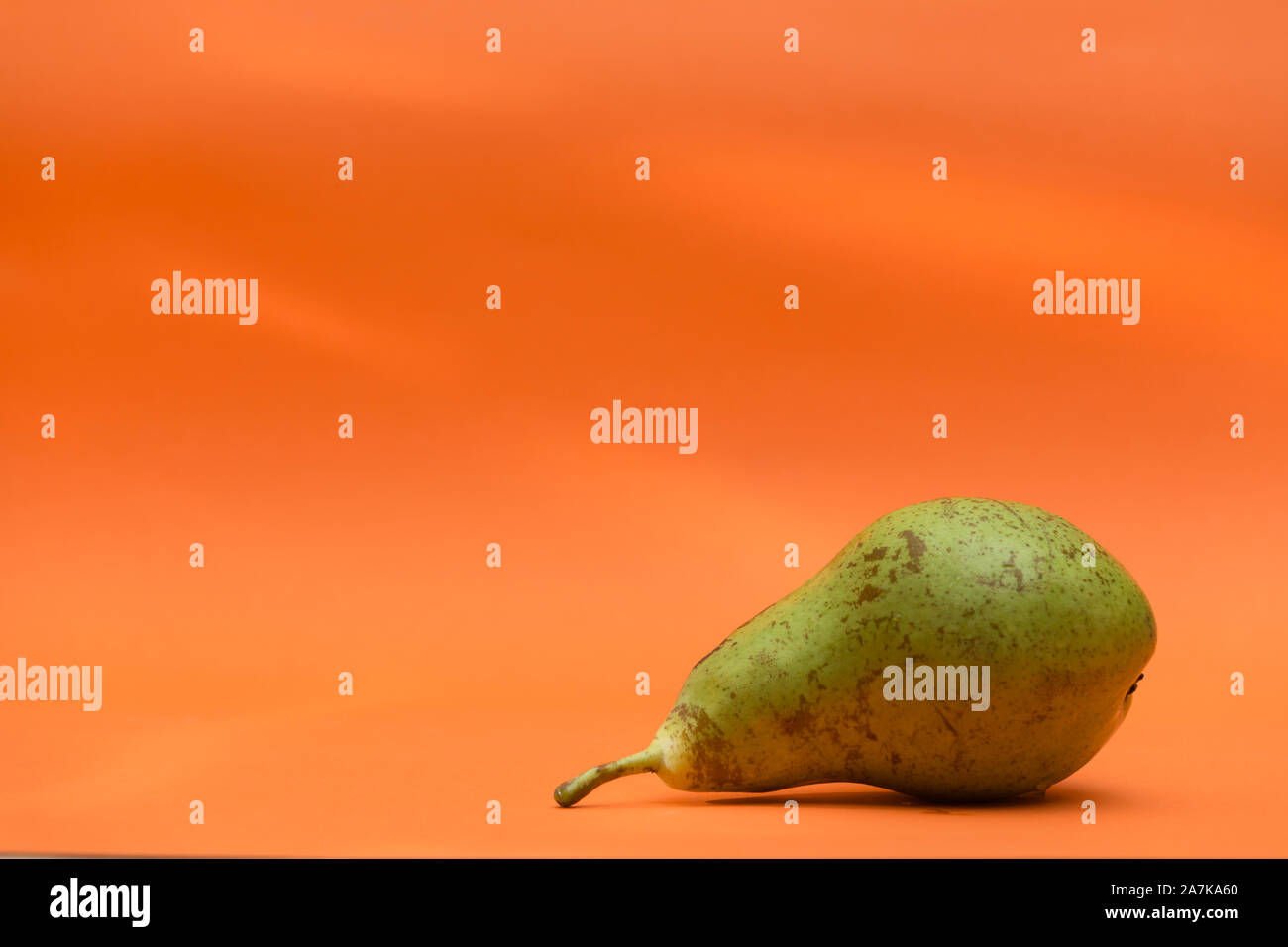 view of a conference pear on an orange background, color contrast Stock ...