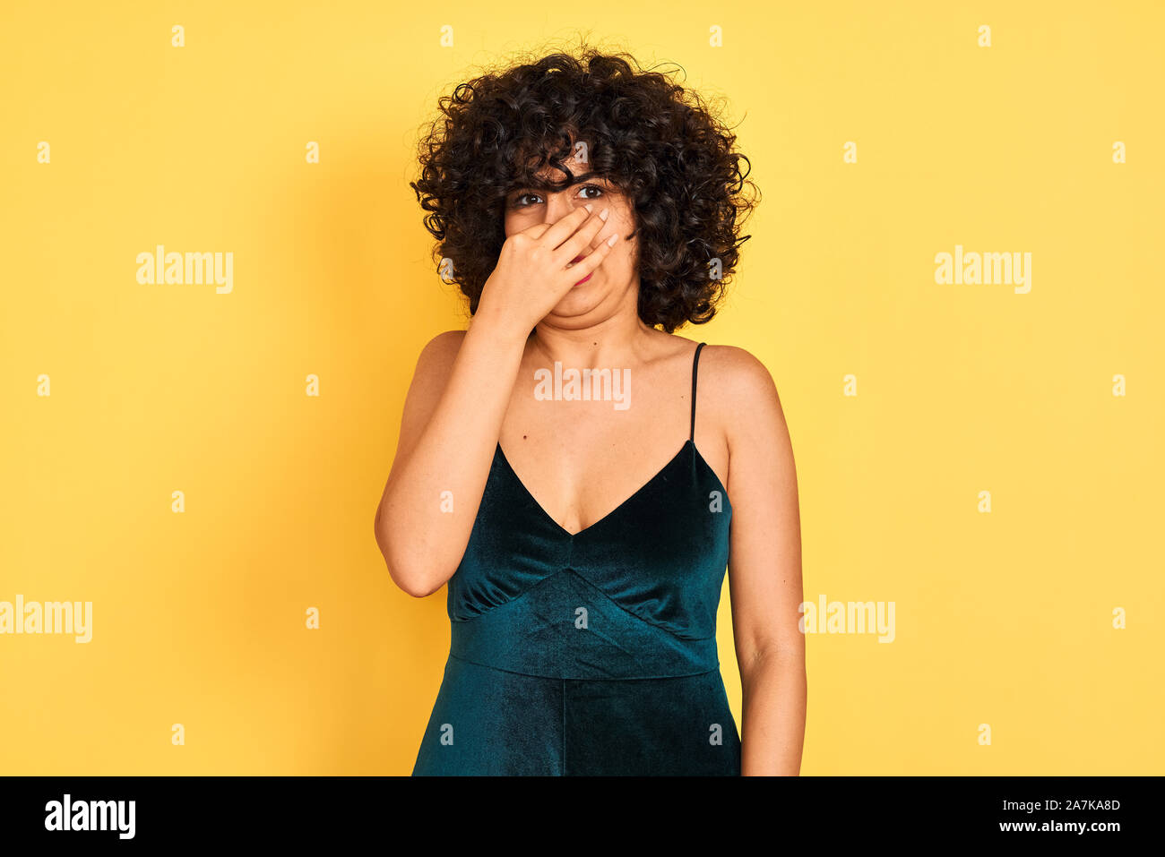 Young arab woman with curly hair wearing elegant dress over isolated ...