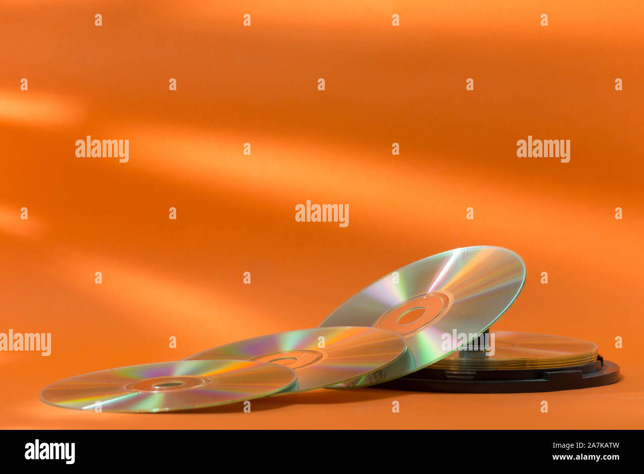 set of cd discs, falling on an orange background Stock Photo - Alamy