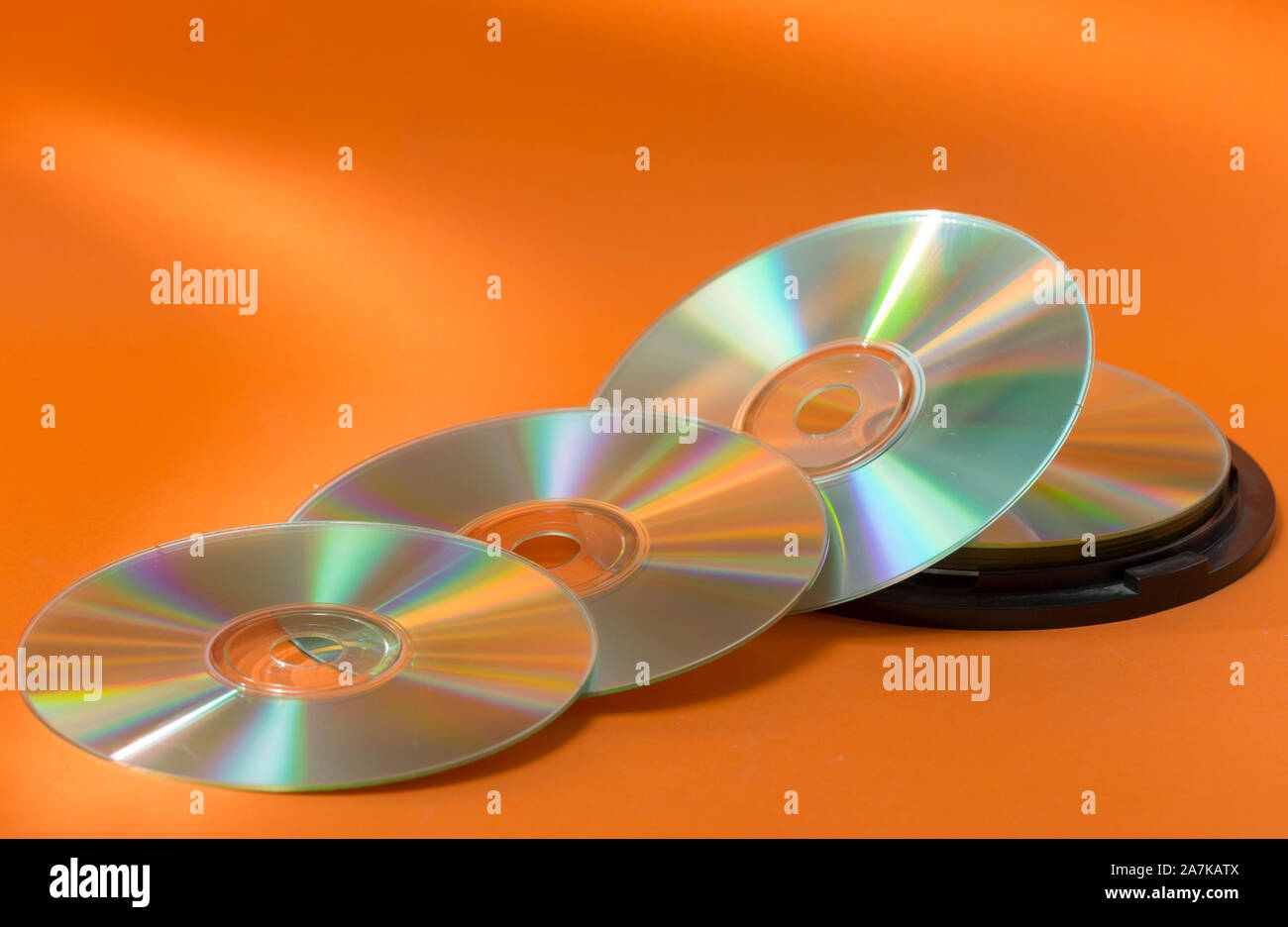 set of cd discs, falling on an orange background Stock Photo - Alamy