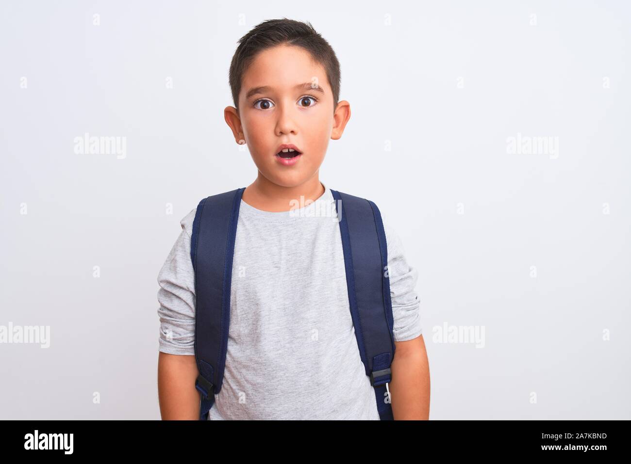 Beautiful student kid boy wearing backpack standing over isolated white ...