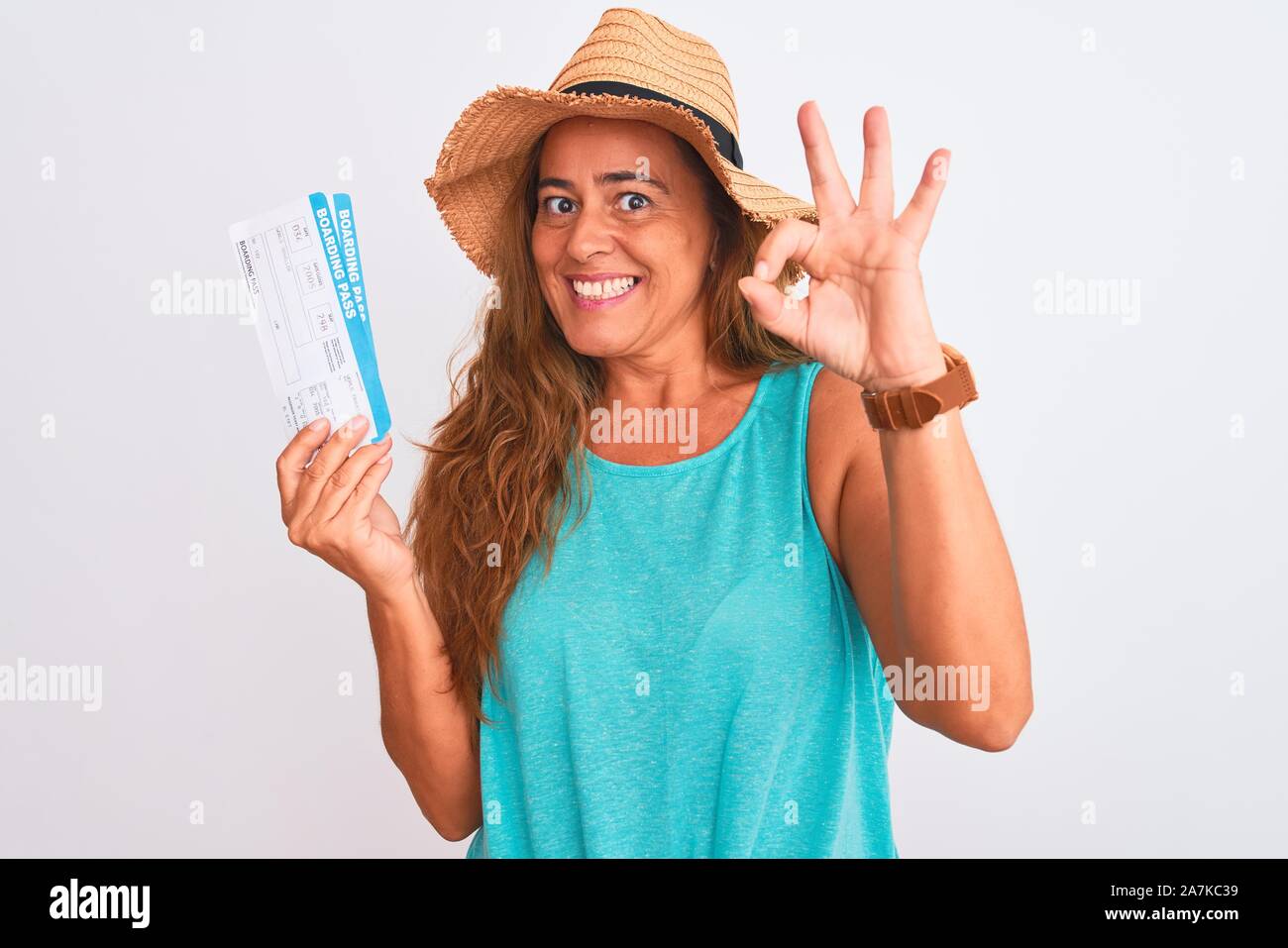 Middle age mature tourist woman holding boarding pass over isolated ...