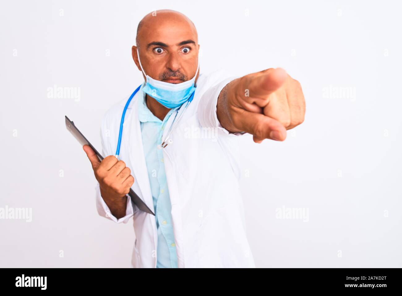 Doctor man wearing stethoscope and mask holding clipboard over isolated ...