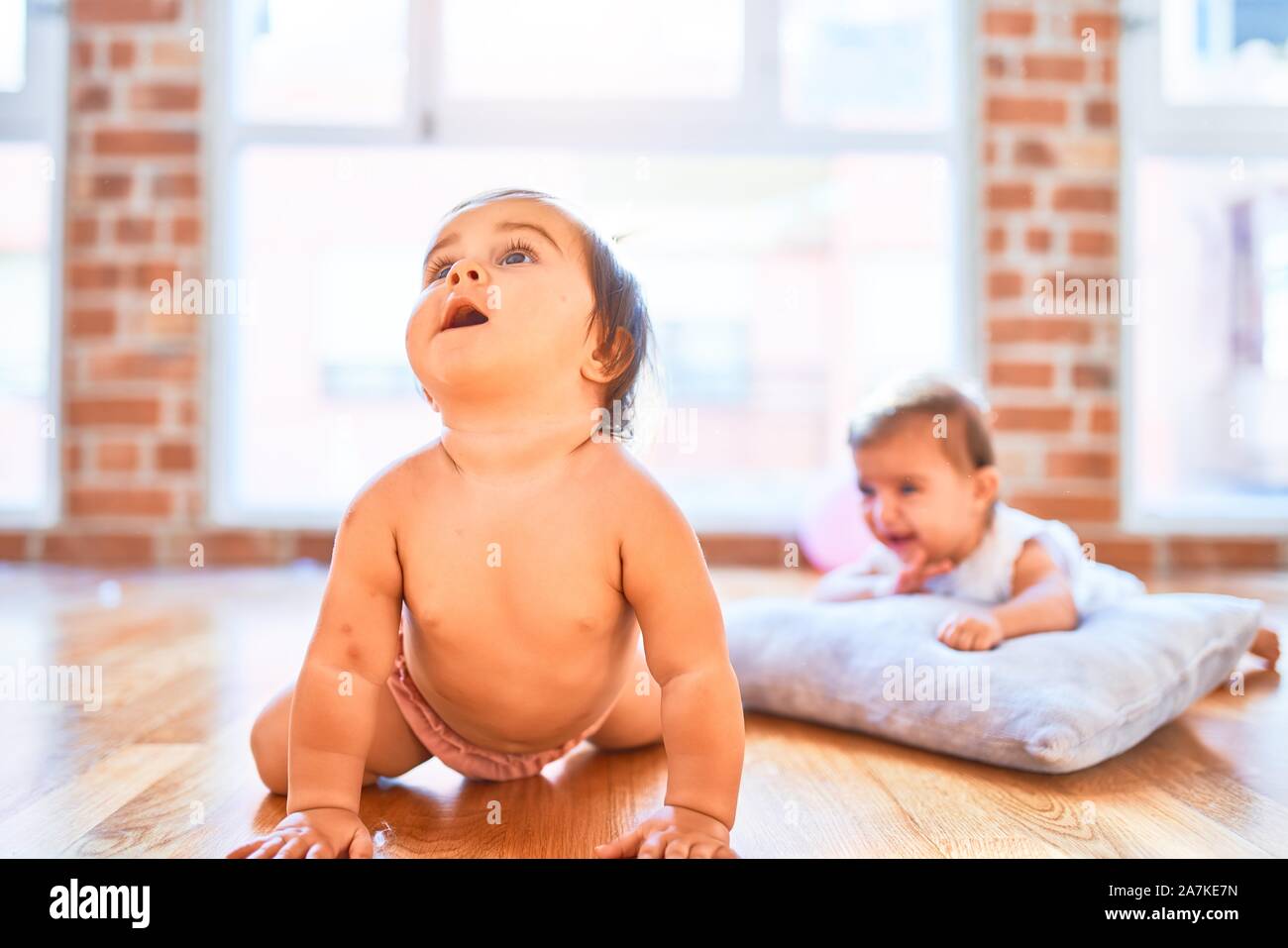 Beautiful infant happy girls playing together at home kindergarten ...