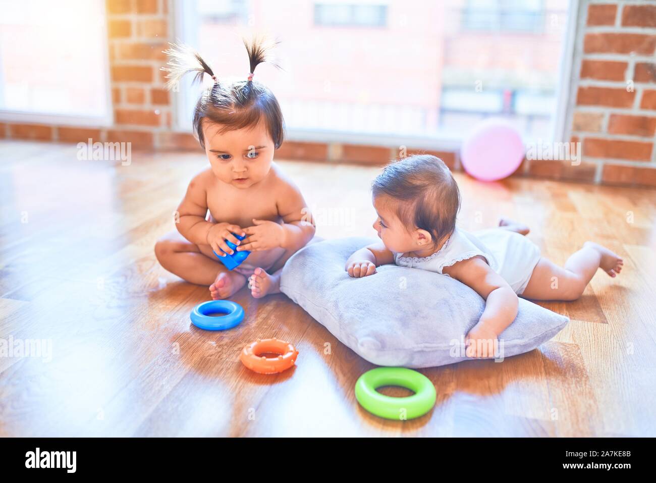 Beautiful infant happy girls playing together at home kindergarten ...
